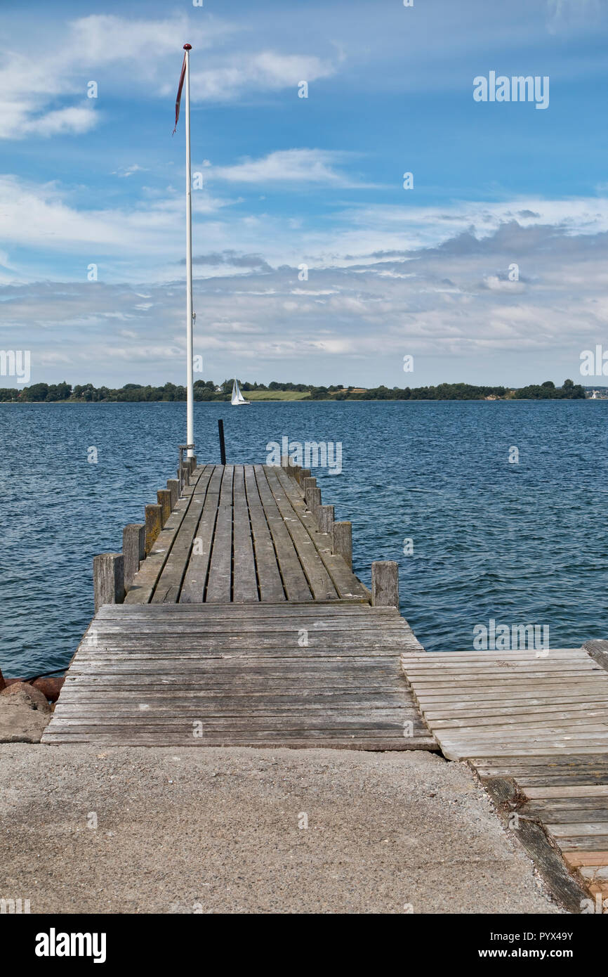 Sailboat passing a bathing jetty on a summer day Stock Photo - Alamy