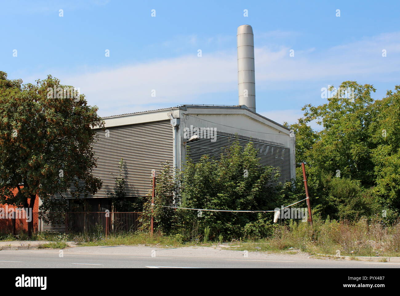 Old abandoned factory with red brick wall and metal insulation, rusted ...