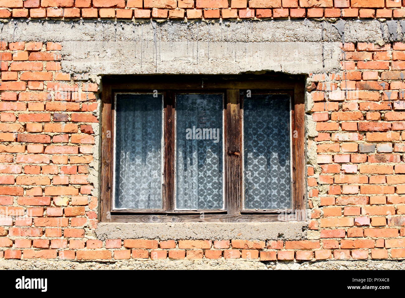 Old dilapidated house window with white curtain and cracked faded ...