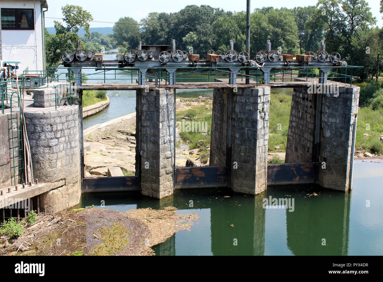 Old small dam made of stone and metal used to regulate and direct water ...