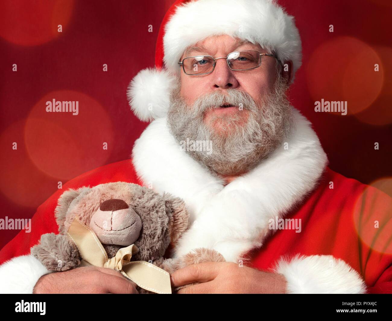 Santa Claus holding teddy bear Stock Photo - Alamy