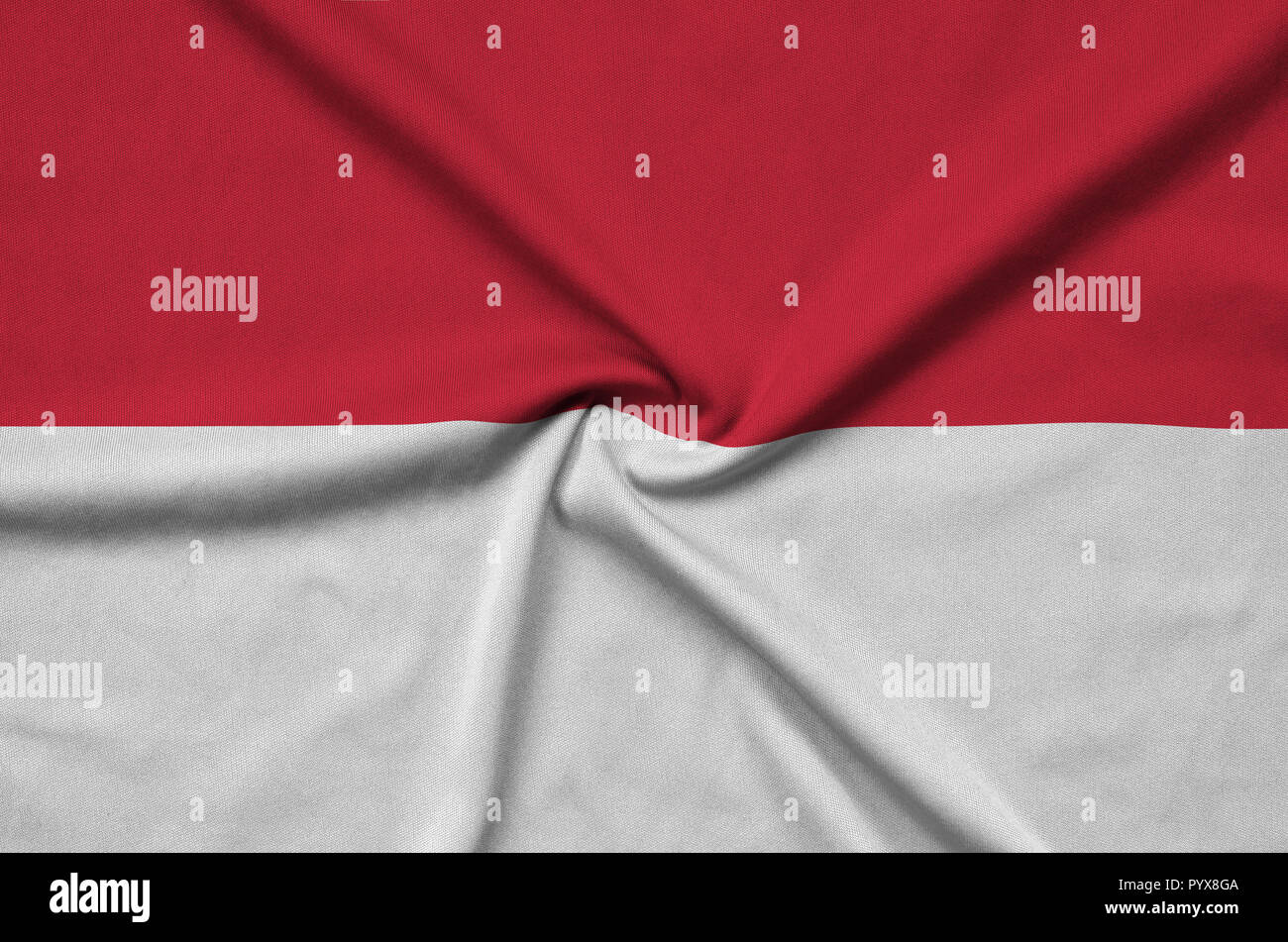Monaco flag is depicted on a sports cloth fabric with many folds. Sport ...