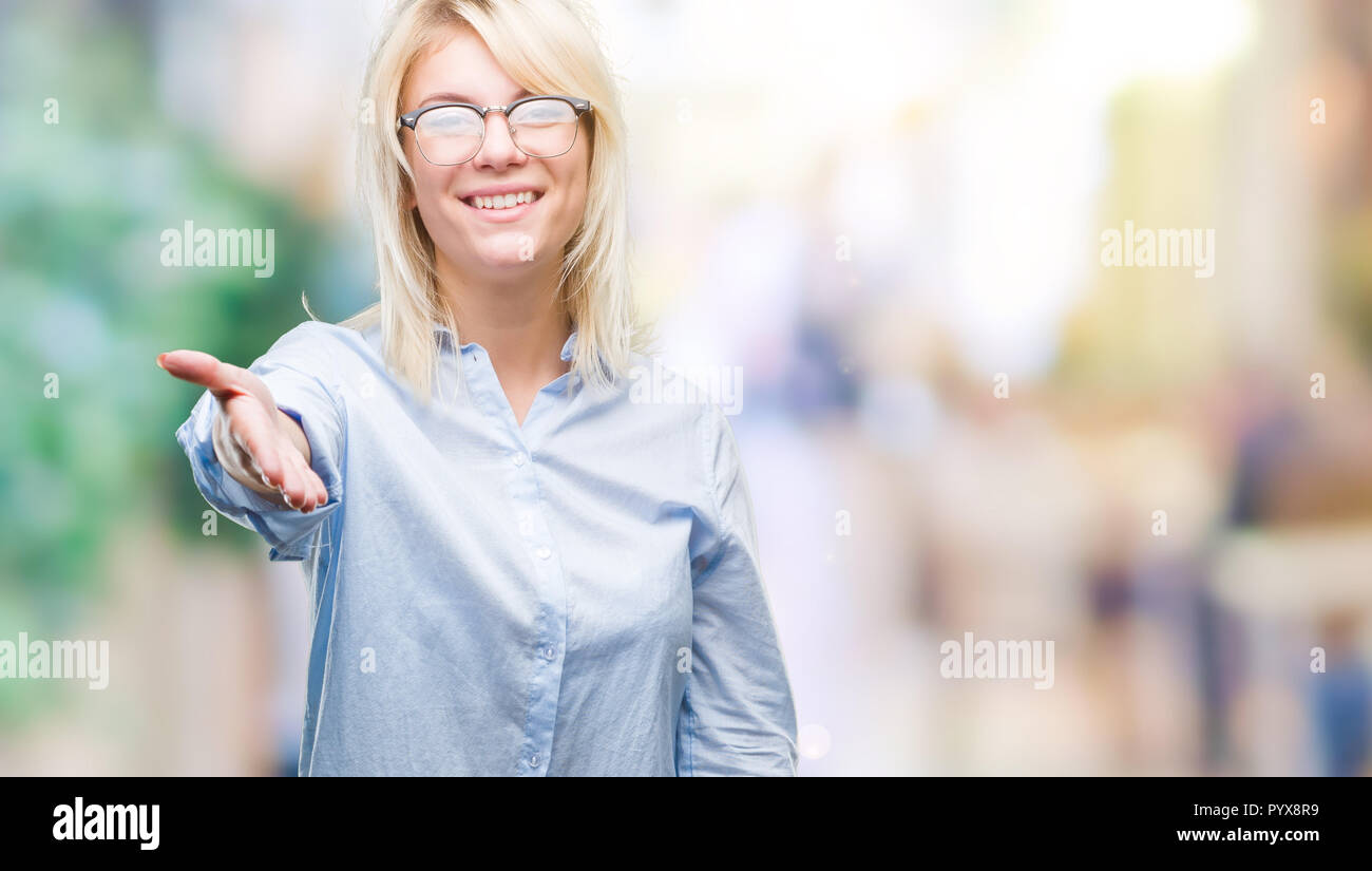 Young beautiful blonde business woman wearing glasses over isolated ...