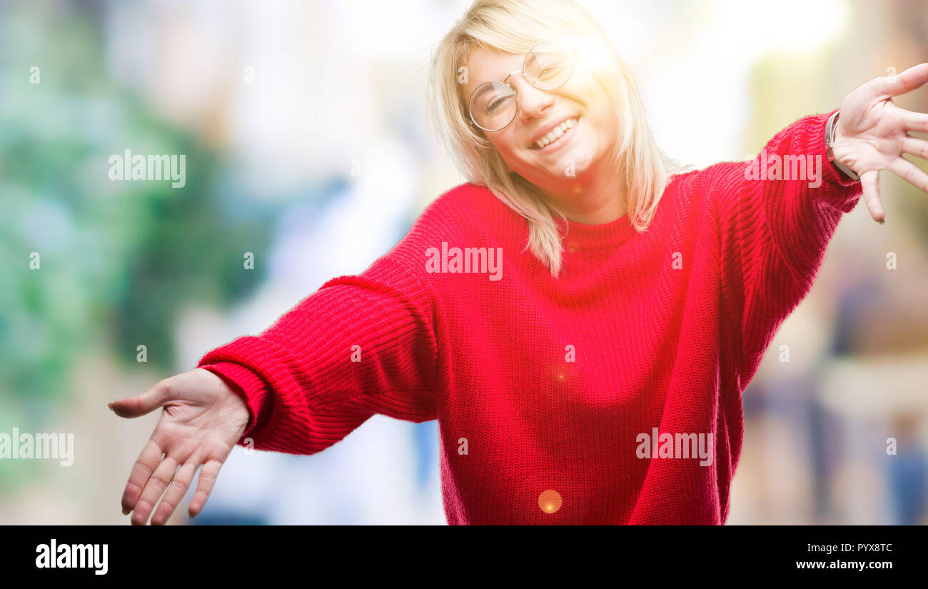 Young beautiful blonde woman wearing sweater and glasses over isolated ...