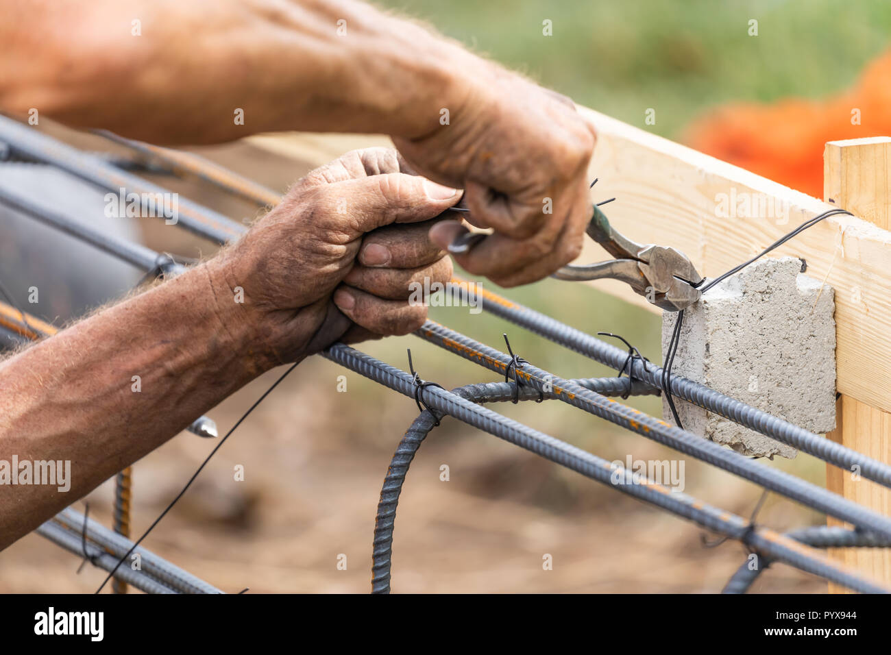 Worker Securing Steel Rebar Framing With Wire Plier Cutter Tool At ...