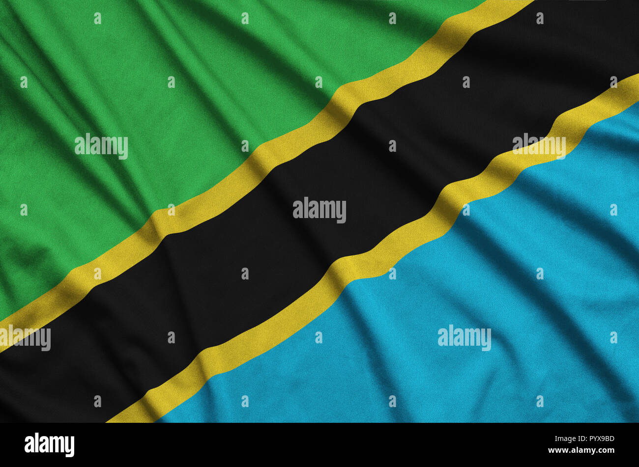 Tanzania flag is depicted on a sports cloth fabric with many folds ...