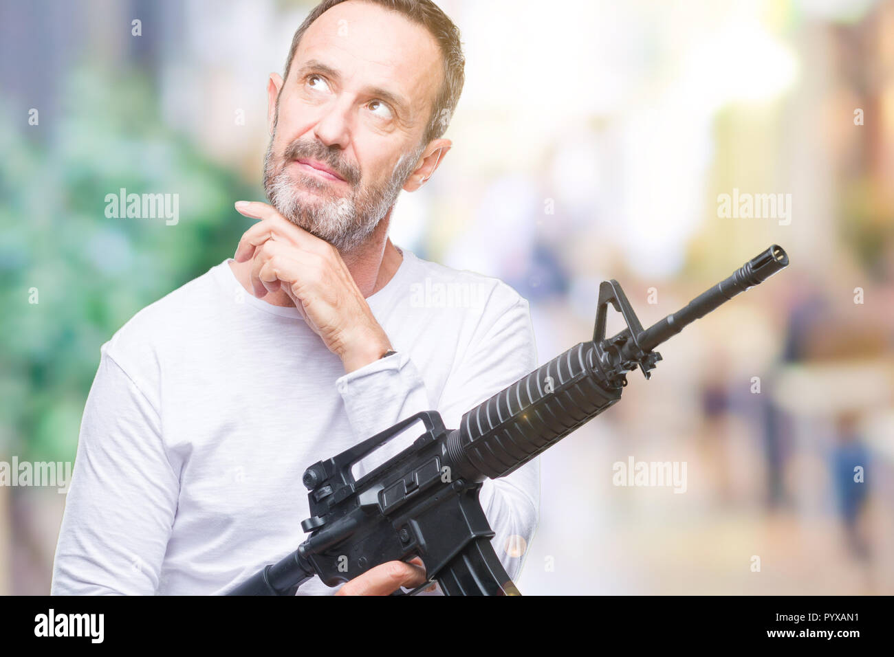 Middle age senior hoary criminal man holding gun weapon over isolated ...