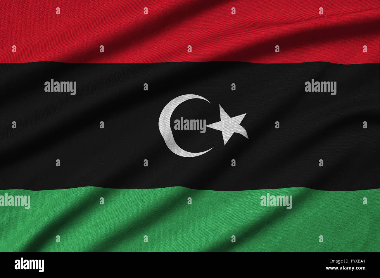 Libya flag is depicted on a sports cloth fabric with many folds. Sport ...