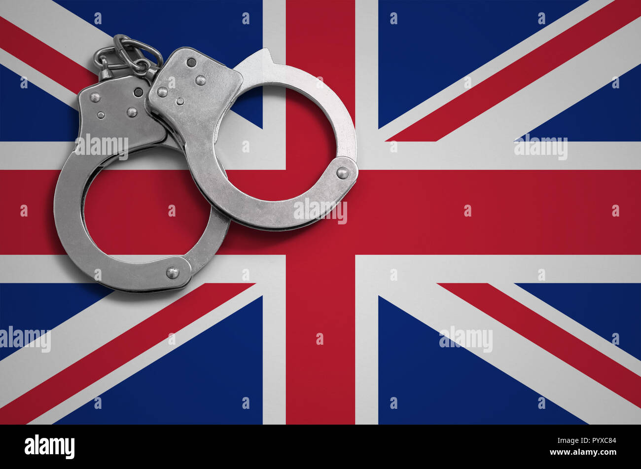 Great britain flag and police handcuffs. The concept of crime and ...
