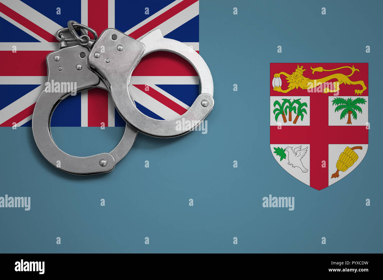 Fiji flag and police handcuffs. The concept of crime and offenses in ...