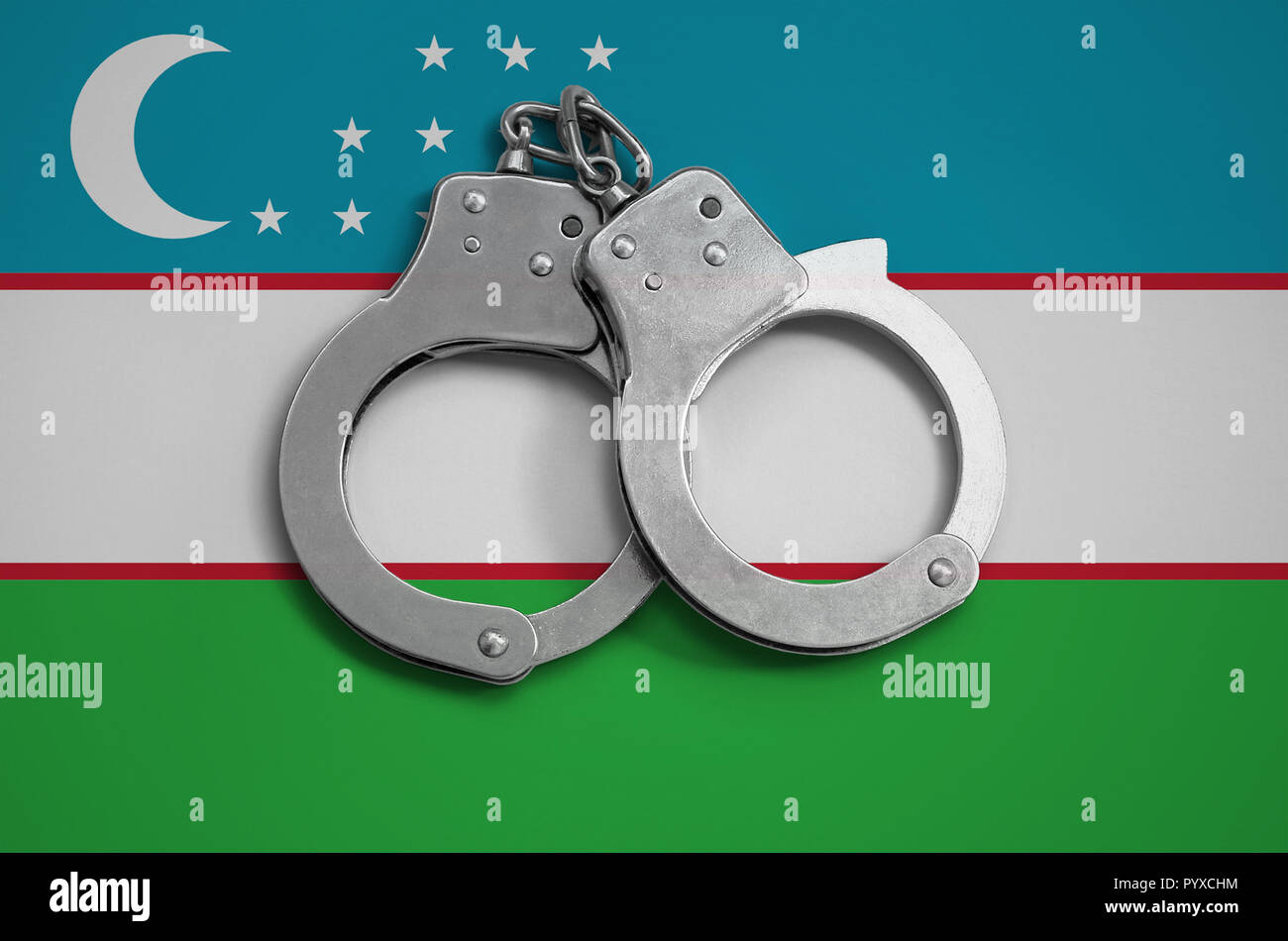 Uzbekistan flag and police handcuffs. The concept of observance of the ...