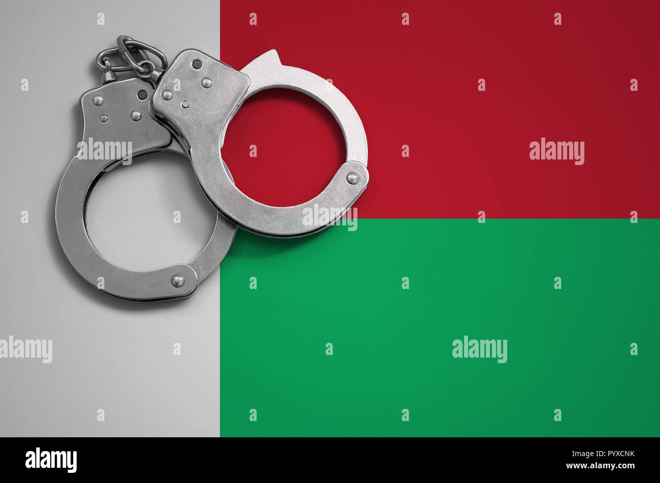 Madagascar flag and police handcuffs. The concept of crime and offenses ...