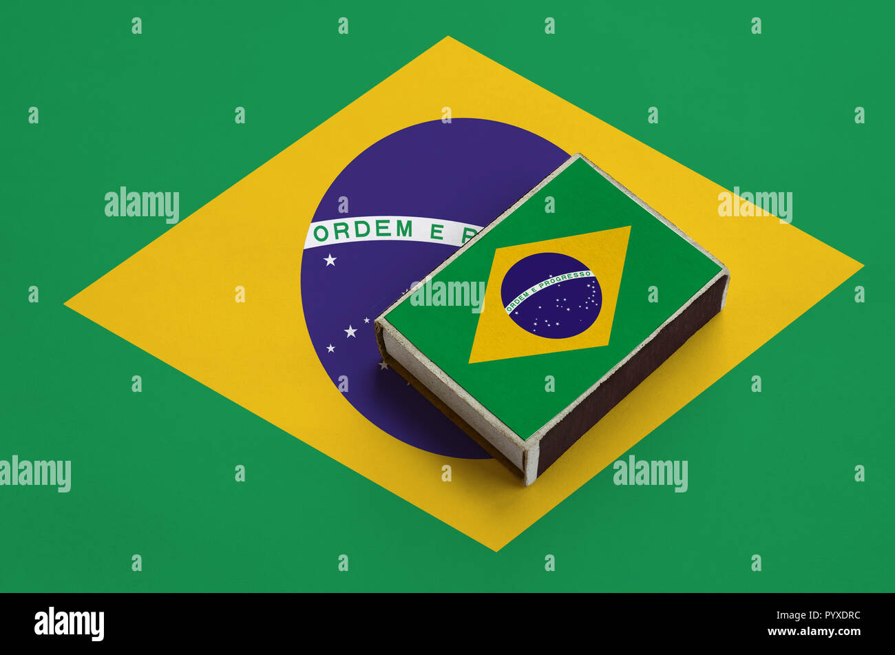 Brazil flag is pictured on a matchbox that lies on a large flag Stock ...
