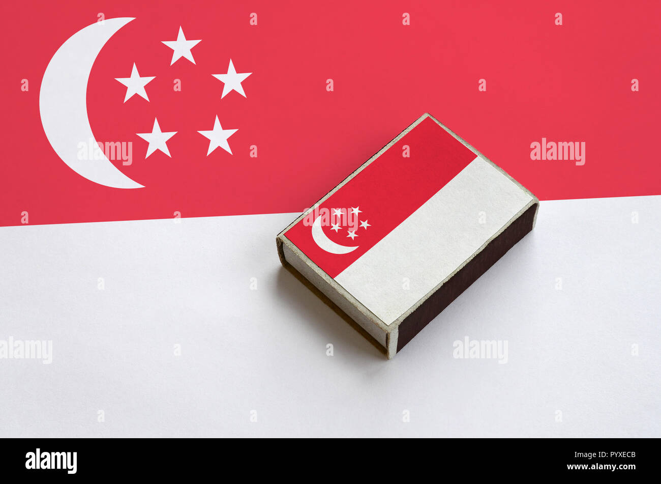 Singapore flag is pictured on a matchbox that lies on a large flag ...