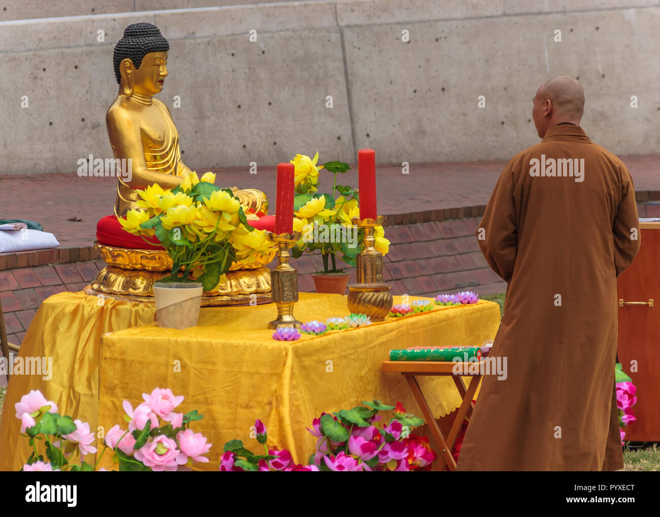 A monk and a table with the statue of buddha Stock Photo - Alamy