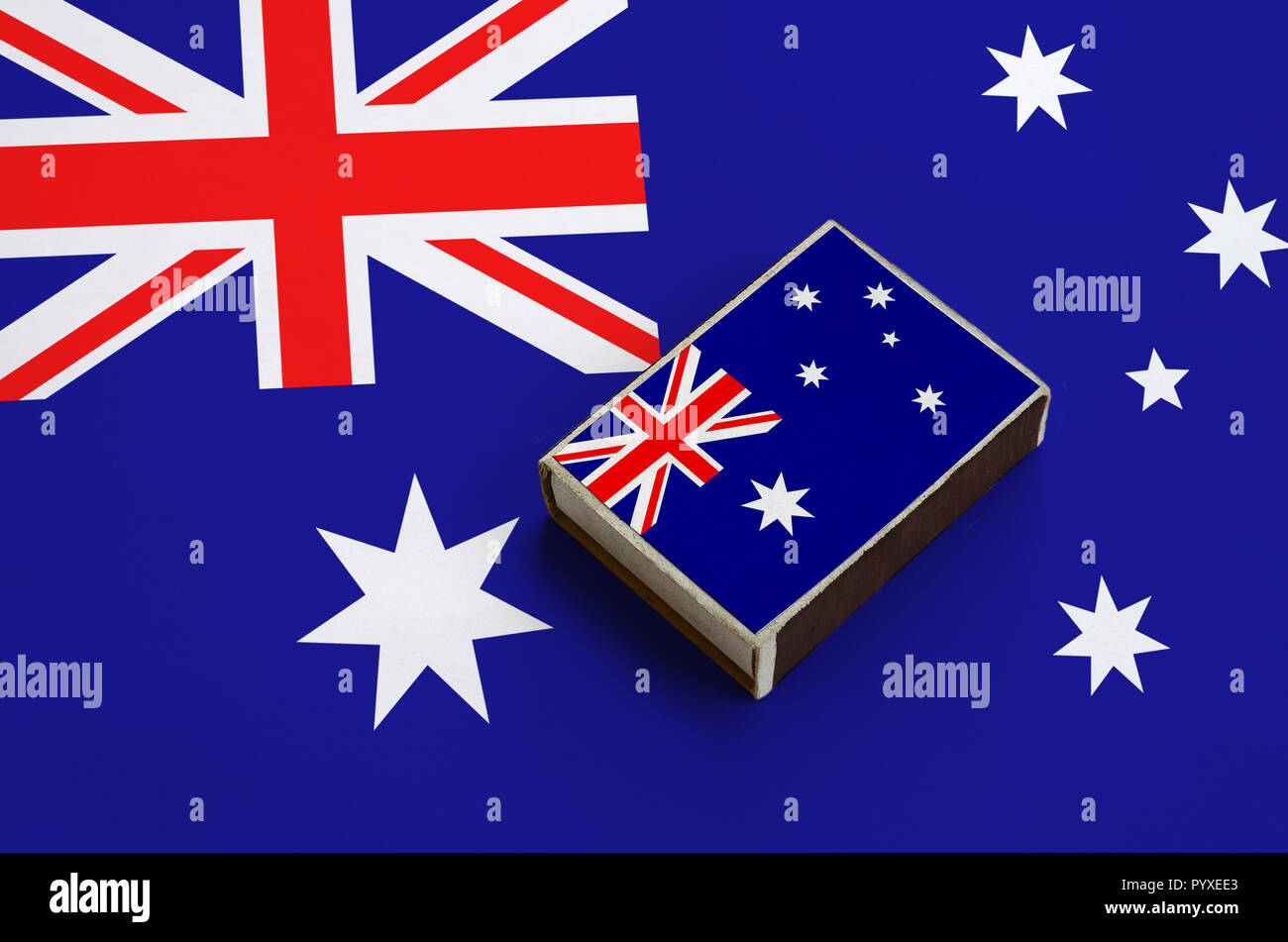 Australia flag is pictured on a matchbox that lies on a large flag ...