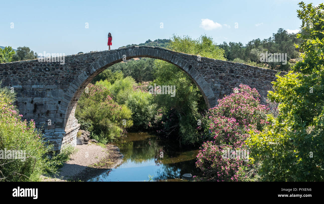 Girl in red dress standing on ancient bridge Stock Photo - Alamy