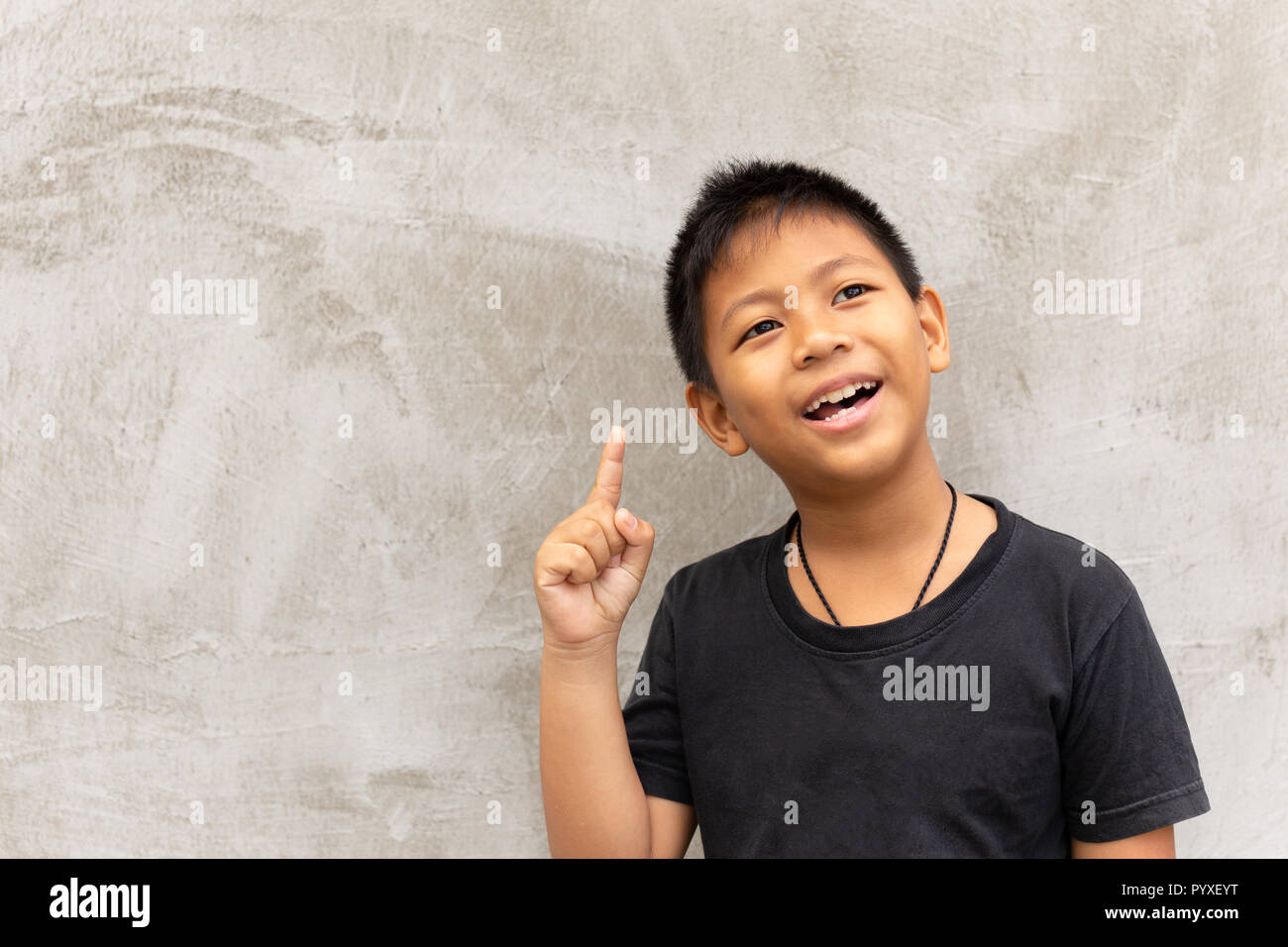 Little asian boy smiling with finger pointing upward Stock Photo - Alamy