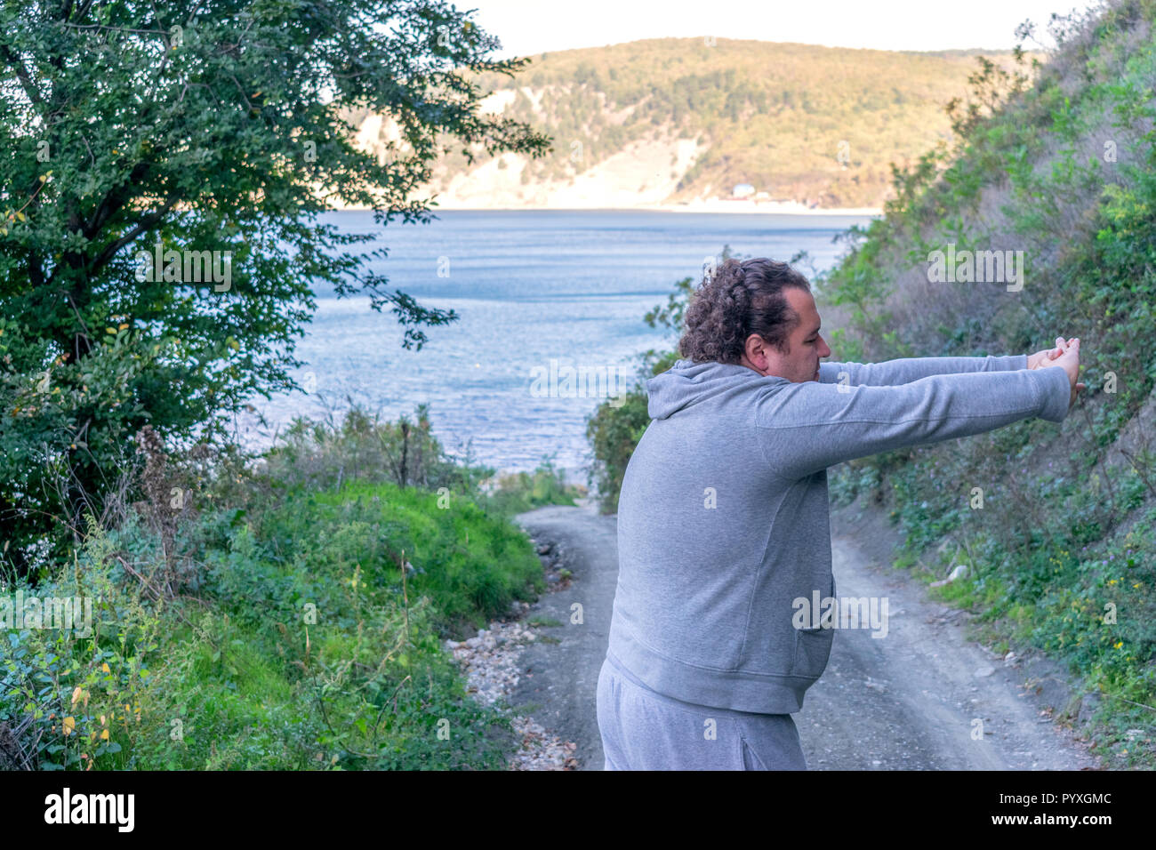 Fat man doing warm-up in nature Stock Photo - Alamy