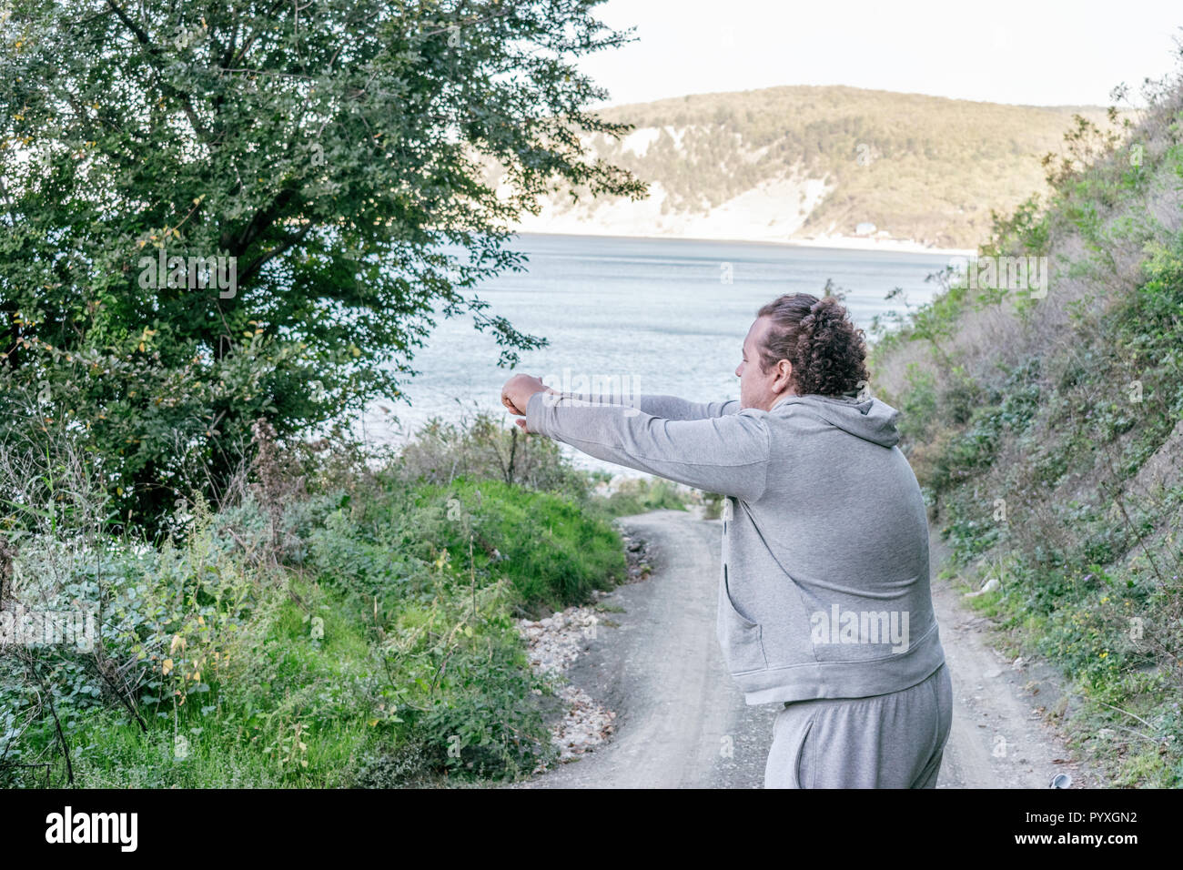 Fat man doing warm-up in nature Stock Photo - Alamy