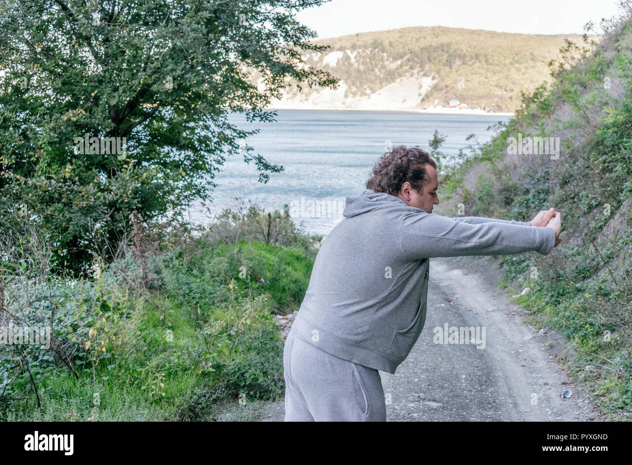 Fat man doing warm-up in nature Stock Photo - Alamy