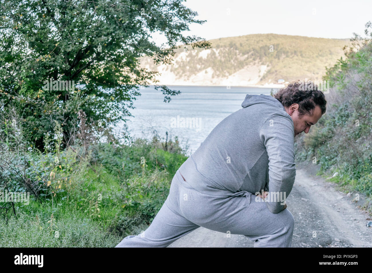 Fat man doing warm-up in nature Stock Photo - Alamy