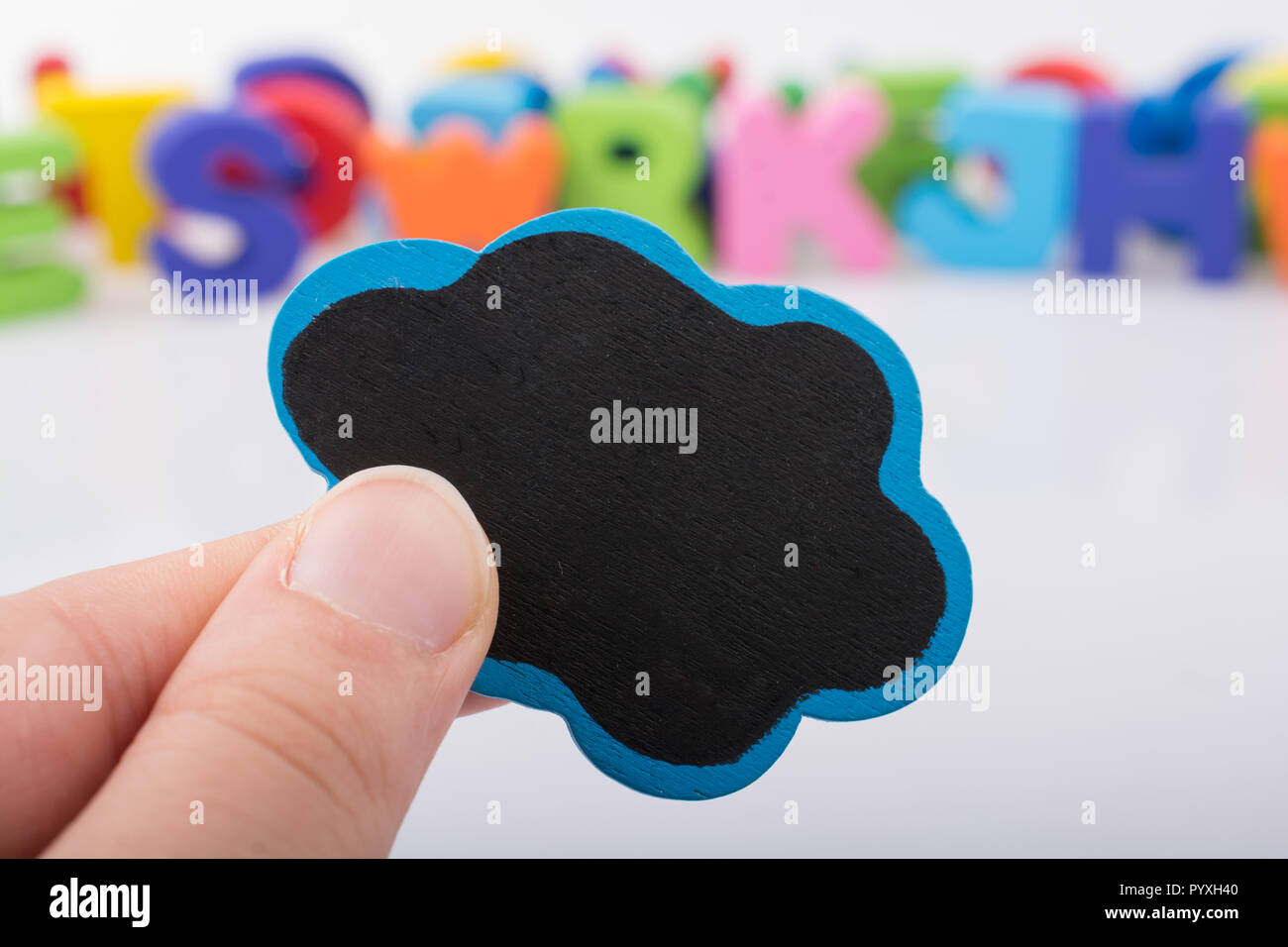 Speech bubble in hand with colorful letters behind Stock Photo - Alamy