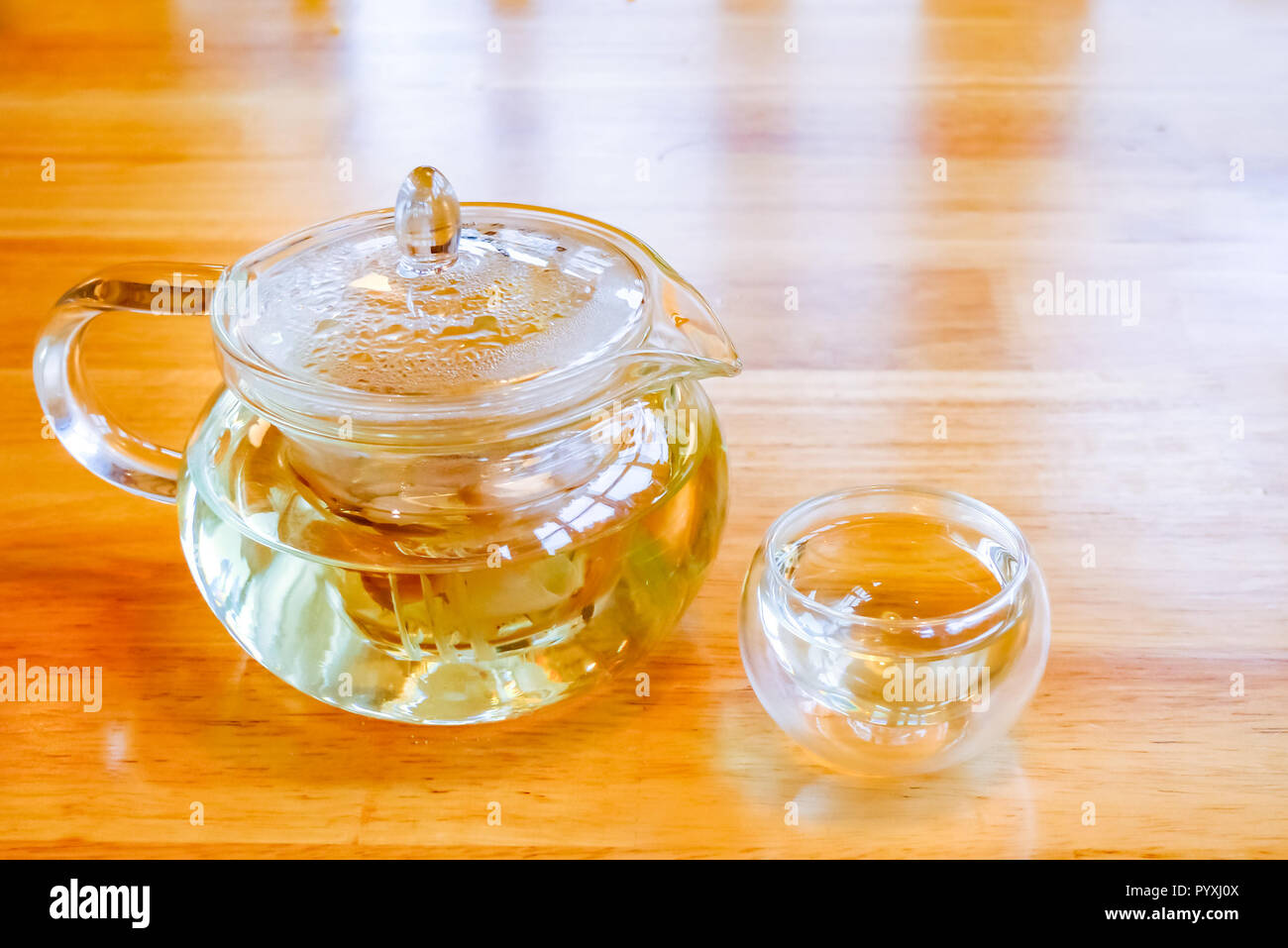 Brightly lit glass teapot and cup on a wood table in China Stock Photo ...