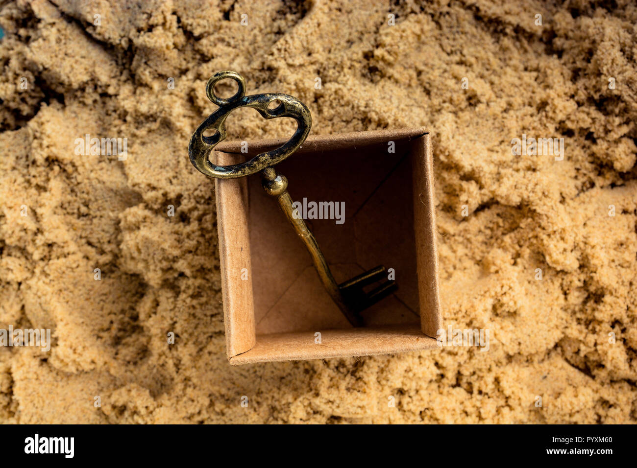 Retro style key placed in a brown box on sand Stock Photo - Alamy