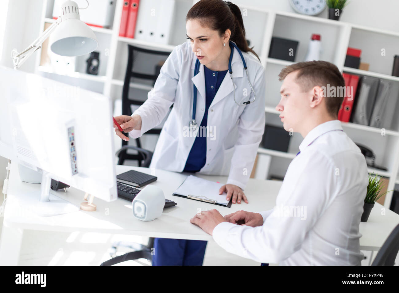 The doctor explains the problem to the patient on the computer Stock ...