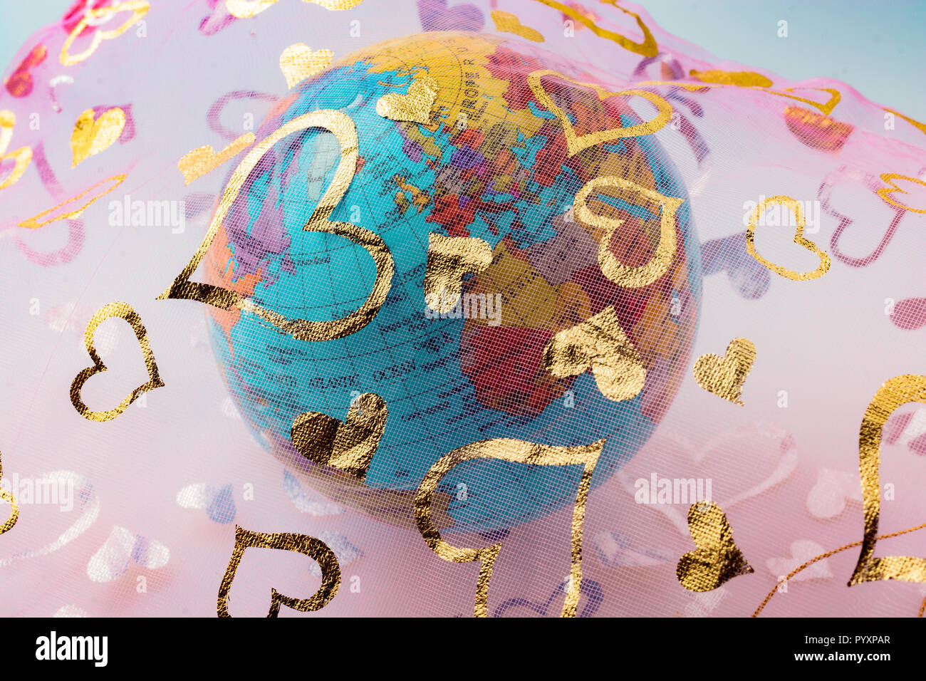 Little model globe under a fabric with heart patterns Stock Photo - Alamy