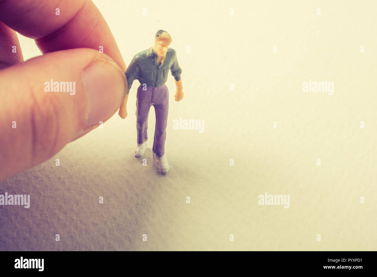 Tiny figurine of man miniature model in hand Stock Photo - Alamy