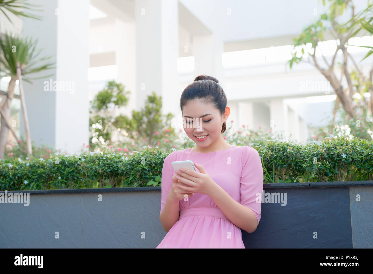 Asian woman wearing traditional dress texting on a smartphone Stock ...