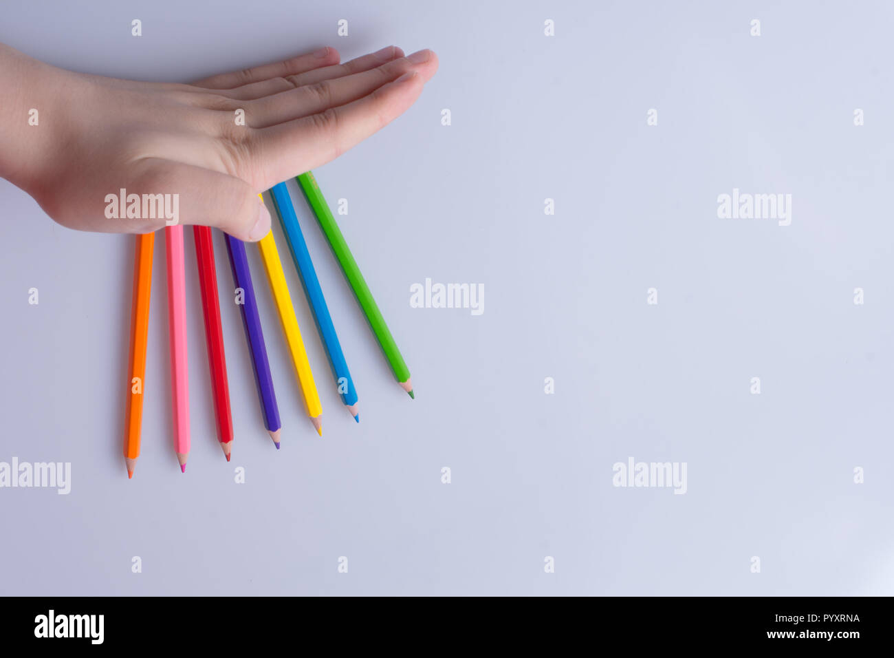 Hand holding color Pencils placed on a white background Stock Photo - Alamy