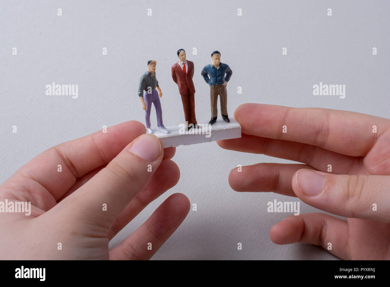 Tiny figurines of men miniature model in hand Stock Photo - Alamy