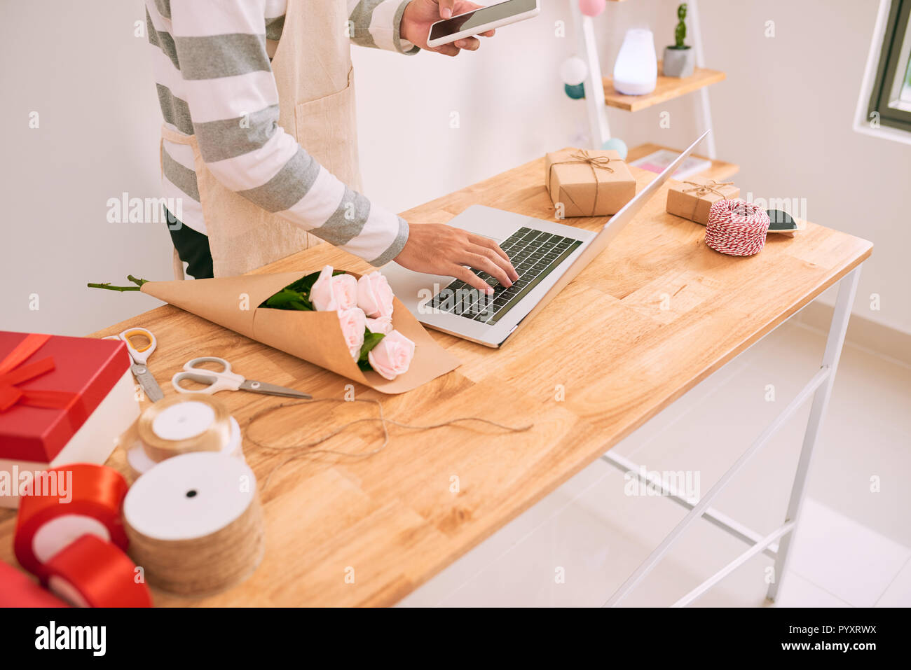 Male florist working with laprop at workplace in flower shop Stock ...