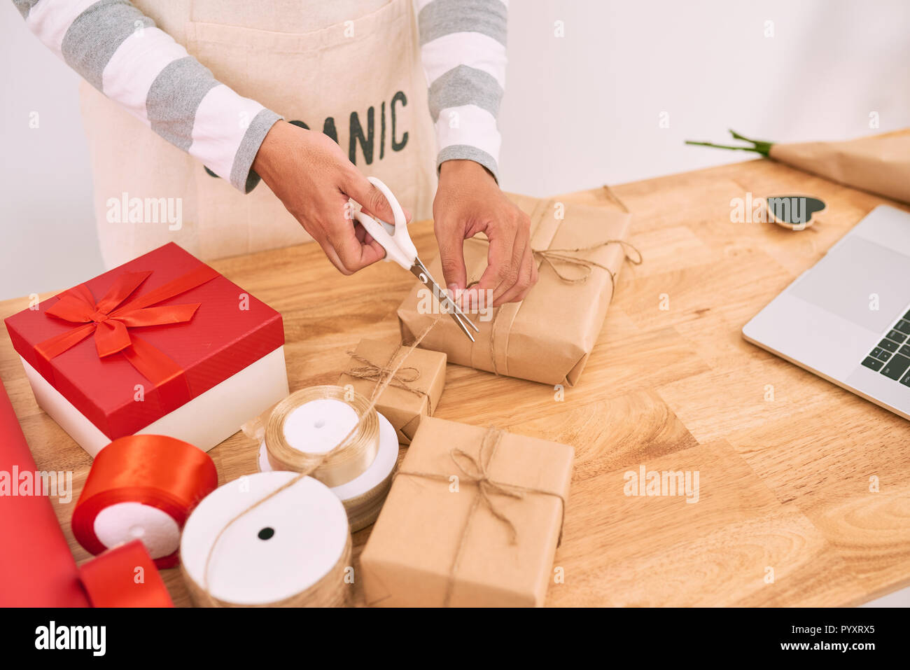 Asian man wrapping purchase while working in shop of gifts Stock Photo ...