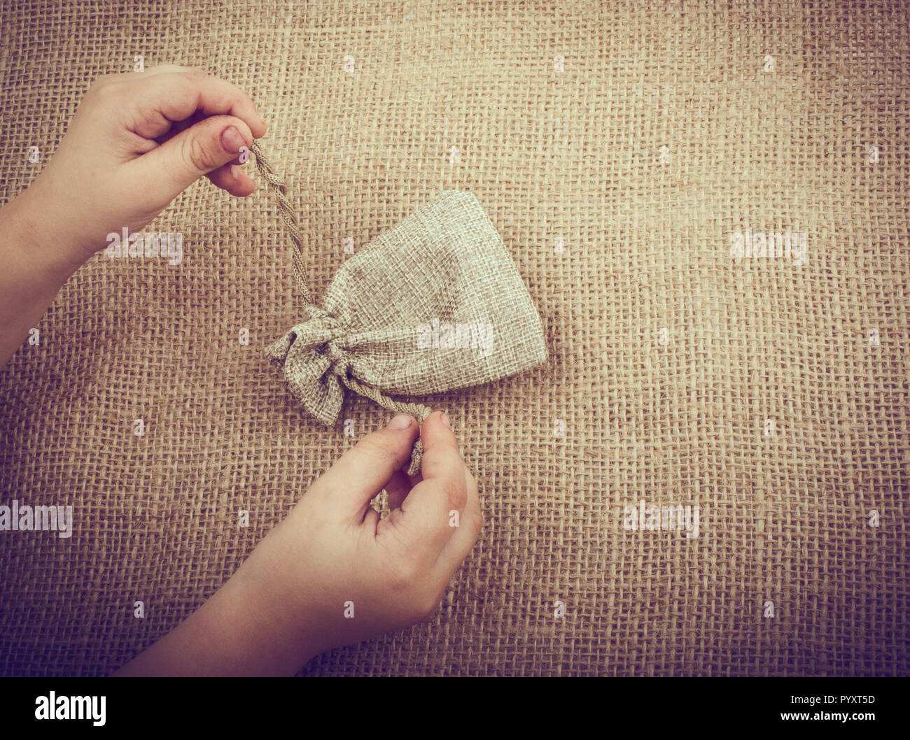 Hand holding an empty little sack made of linen Stock Photo - Alamy