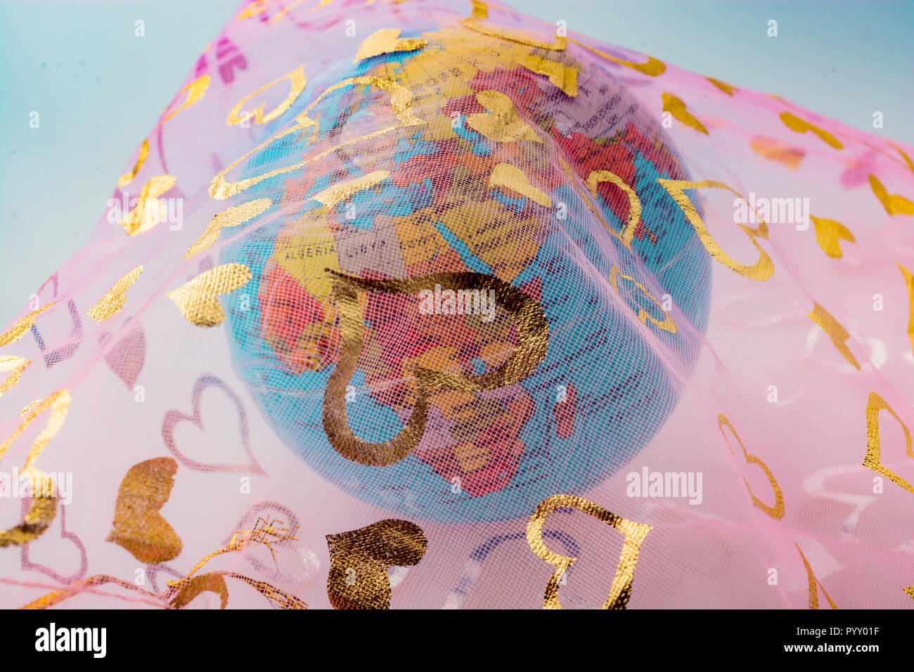 Little model globe under a fabric with heart patterns Stock Photo - Alamy