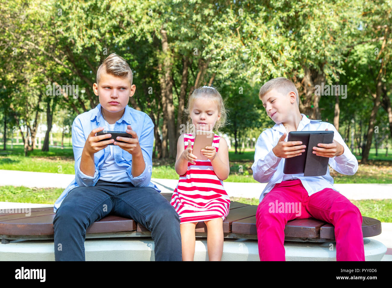 Group of busy kids looking at their phones texting sms and playing ...