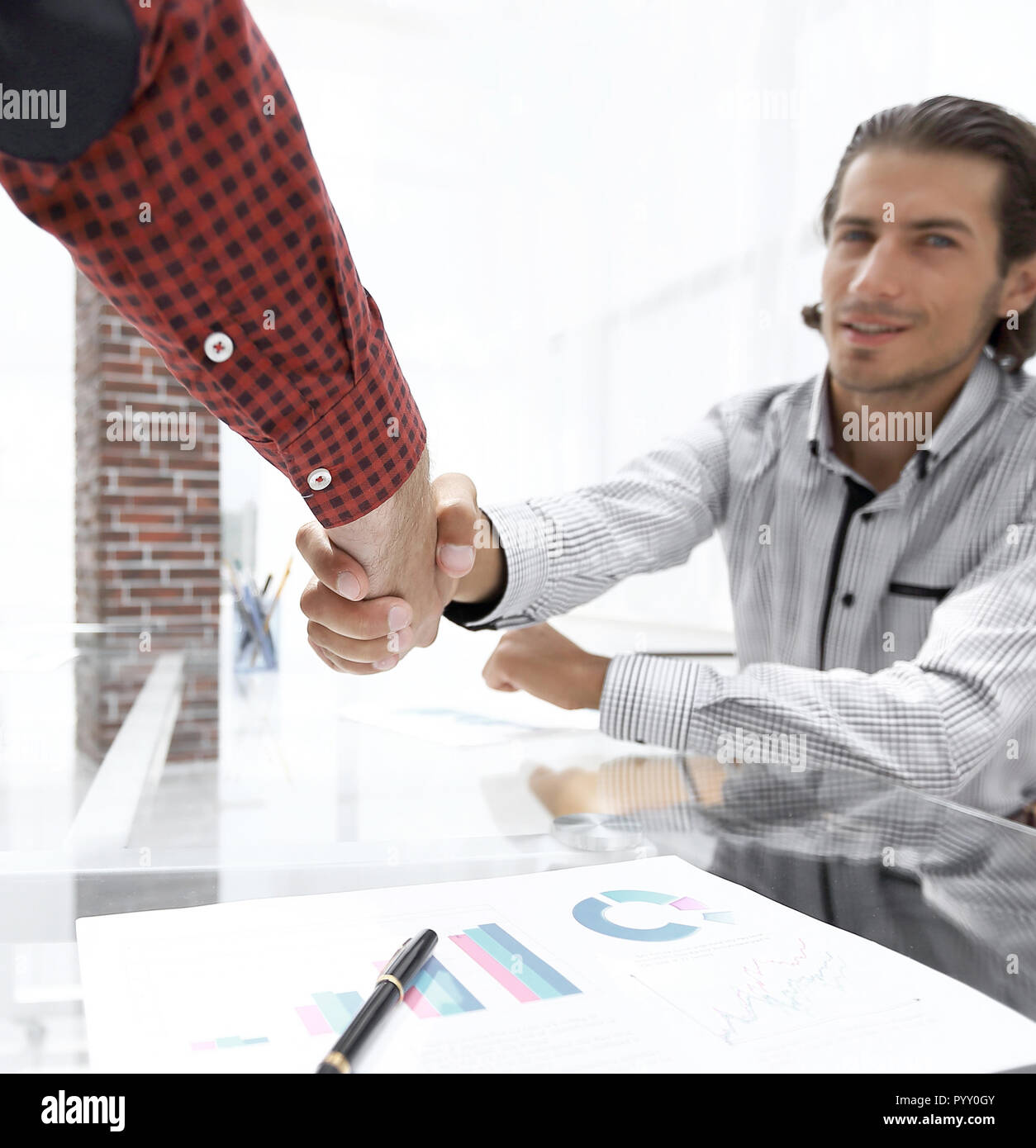 colleagues shaking hands over Desk Stock Photo - Alamy