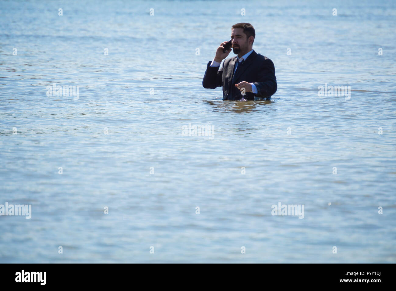Businessman speaking on a phone in a deep water Stock Photo - Alamy