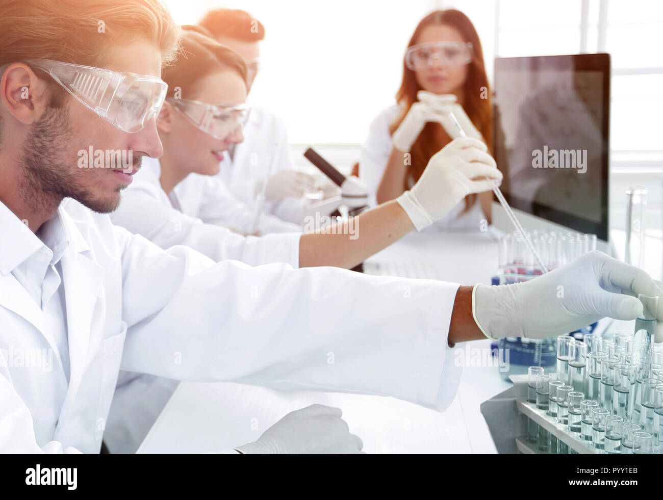 Scientists working with a microscope and make notes in the workplace ...