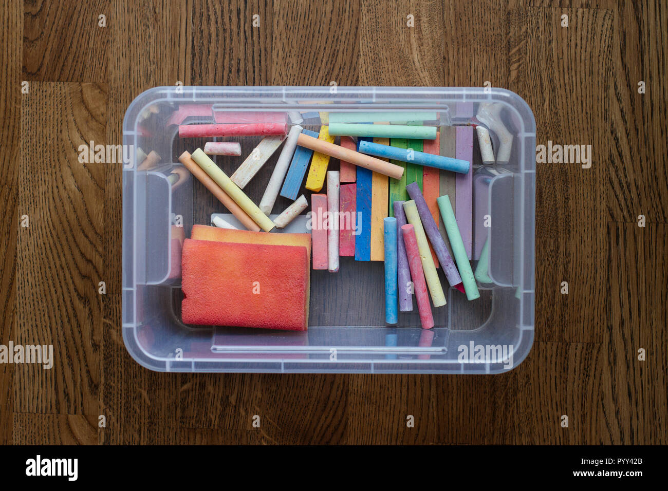 top view closeup of transparent toy container box with colored drawing ...