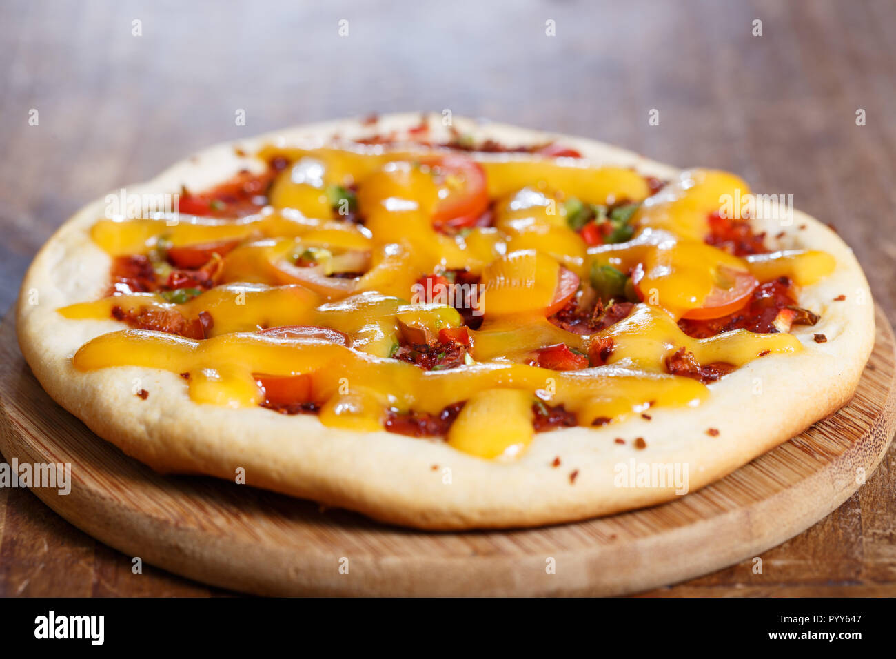 A mini pizza on a brown wooden table. These small pies also called ...