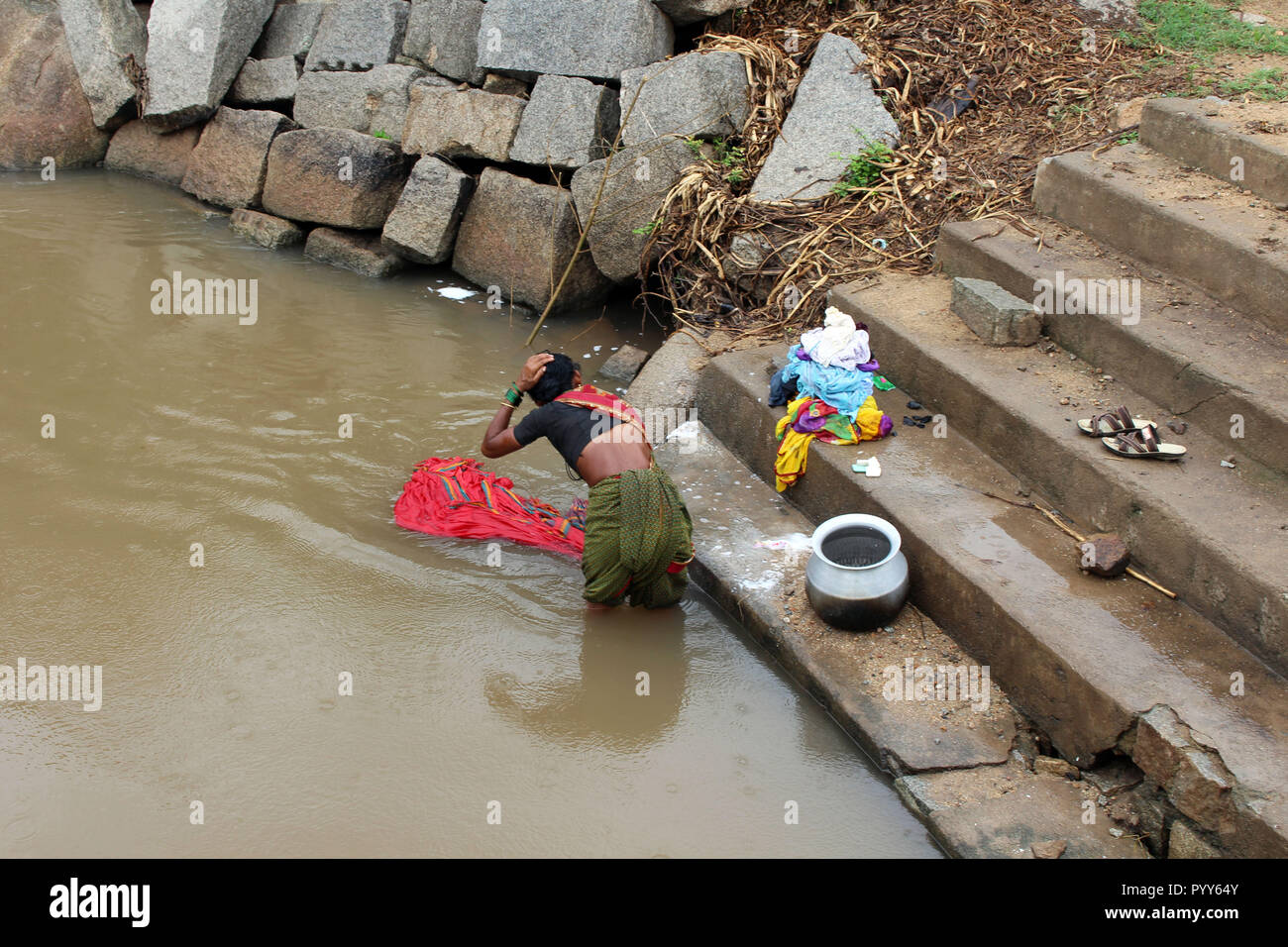 Local Indian people washing clothes on the river in Hampi. Taken in ...