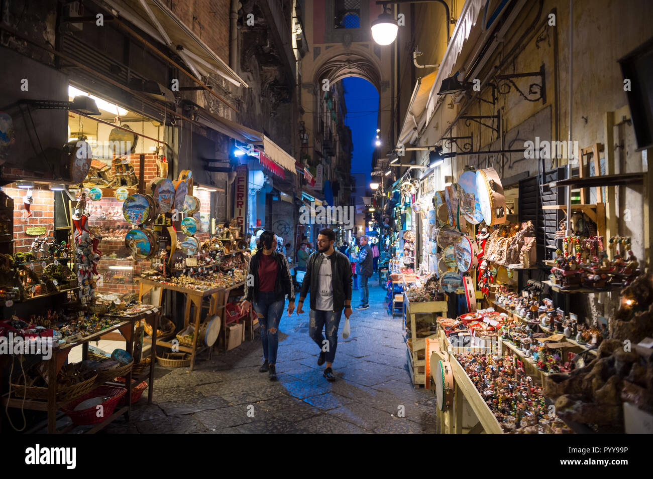 NAPLES, ITALY - CIRCA OCTOBER, 2017: Pedestrians pass displays of ...