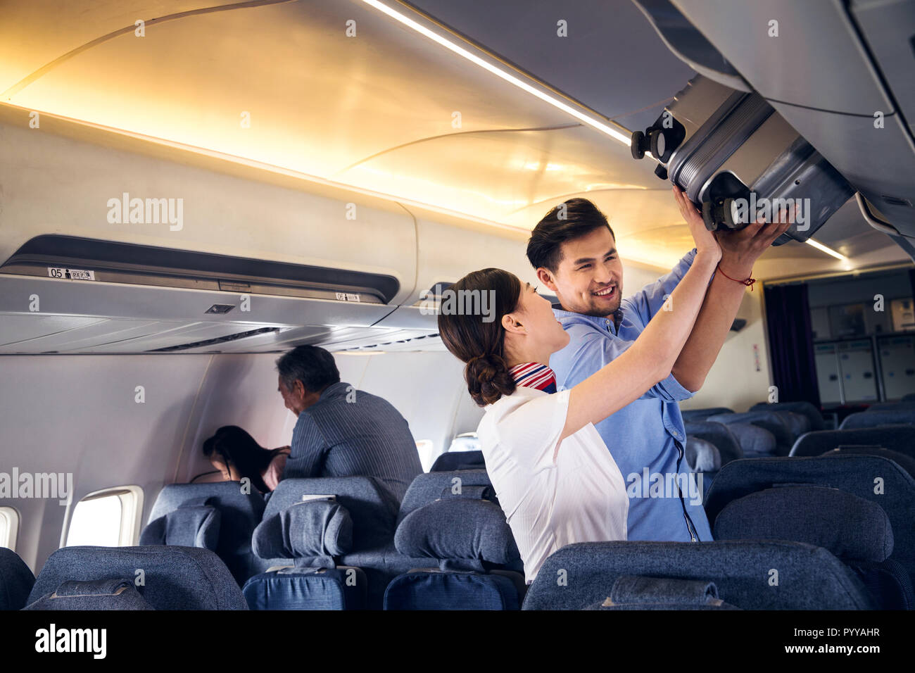 Flight attendants and passengers on the plane Stock Photo - Alamy
