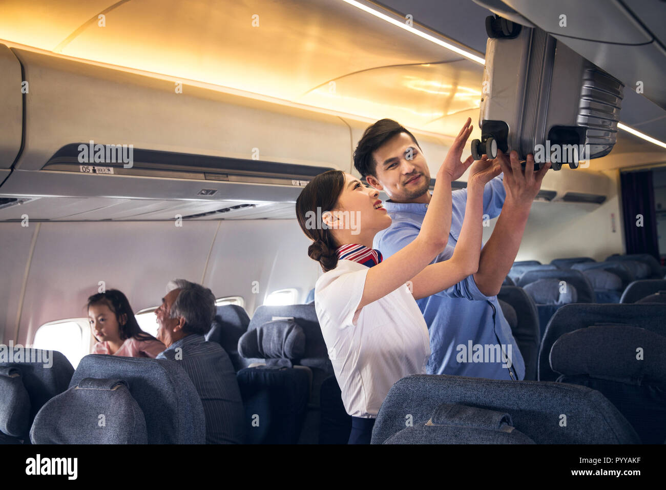 Flight attendants and passengers on the plane Stock Photo - Alamy