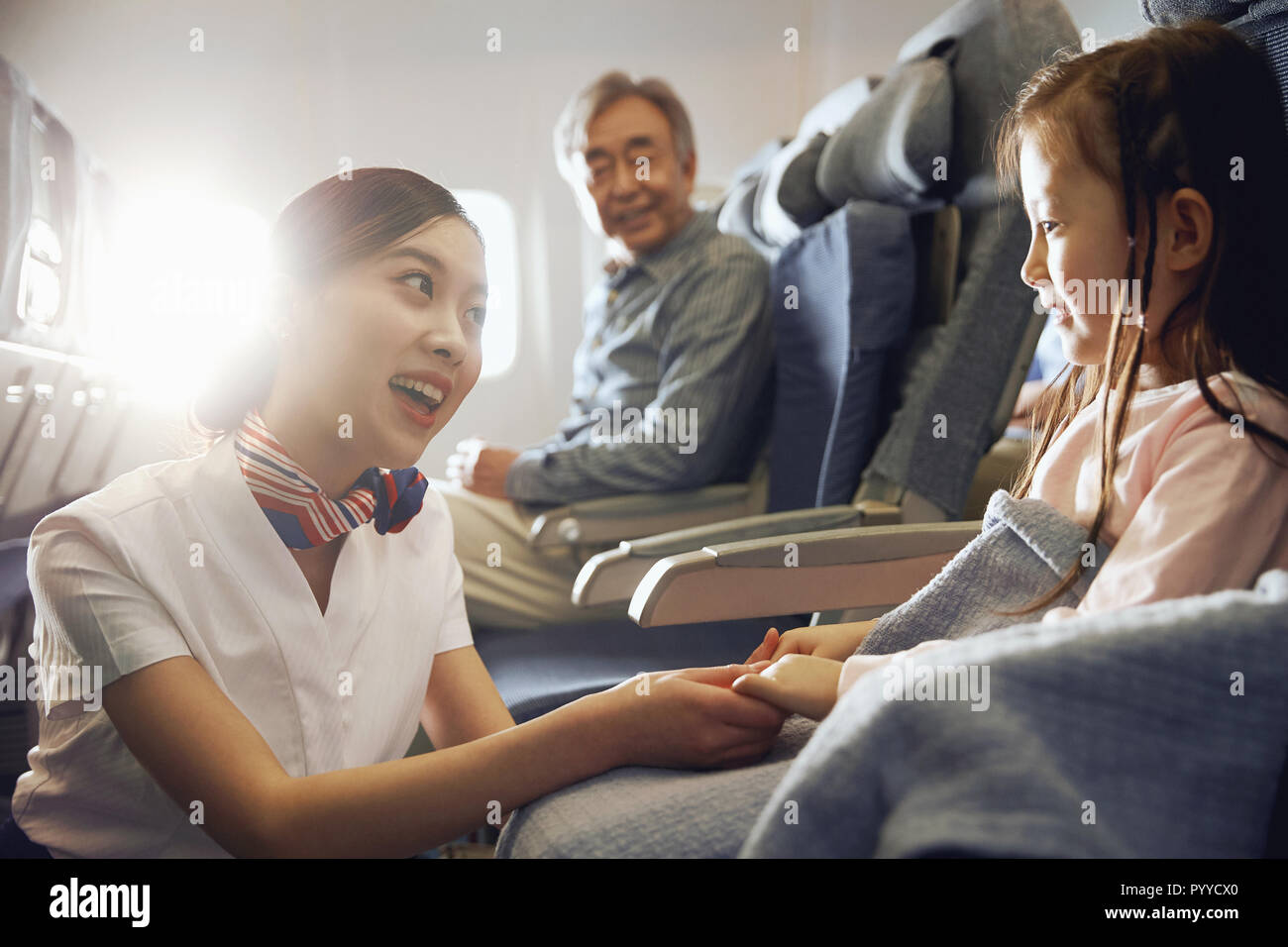 Flight attendants and passengers on the plane Stock Photo - Alamy